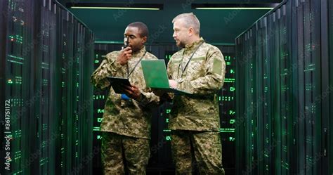 Multiethnic Male Army Officers With Tablet Device And Laptop Computer Checking Secret Data In