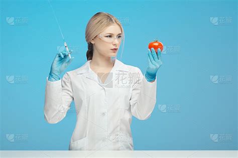 实验室里的一位女生物学家，穿着白大褂，戴着橡胶手套，背景是蓝色。用注射器给红色的番茄注射毒品。