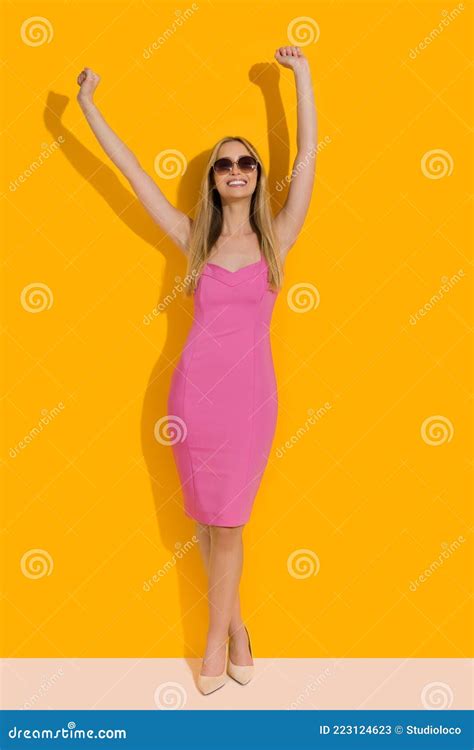 элегантная счастливая молодая женщина стоит с поднятыми руками Стоковое Изображение
