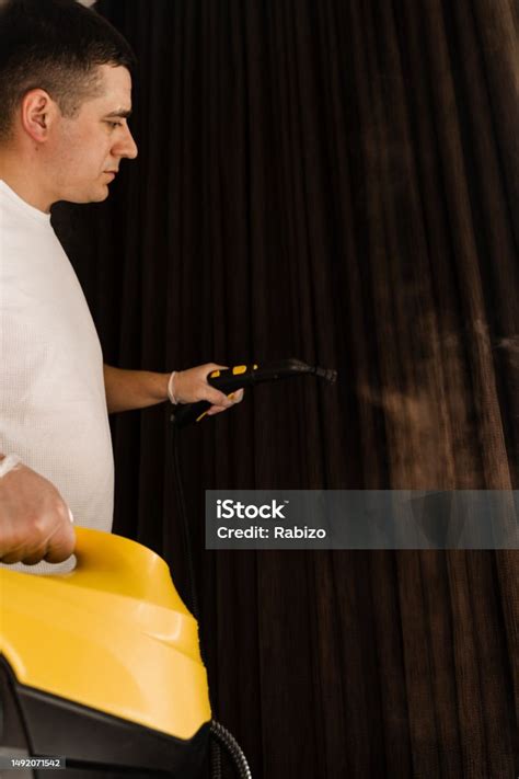 커튼 스팀 청소 과정 집에서 커튼의 소독 및 드라이 클리닝 클리너는 전문 스팀 기계를 사용하여 커튼을 찜질하고 있습니다 30 34세에 대한 스톡 사진 및 기타 이미지