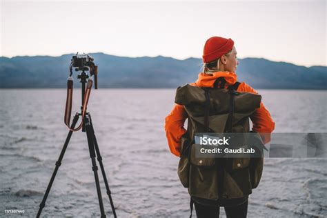 배드워터 국립공원에서 여행하는 동안 배낭을 들고 사진을 찍는 여성 여행자의 뒷모습 아름다운 풍경과 풍경의 비디오를 촬영하기 위해 삼각대 근처에 서있는 숙련 된 여성 사진