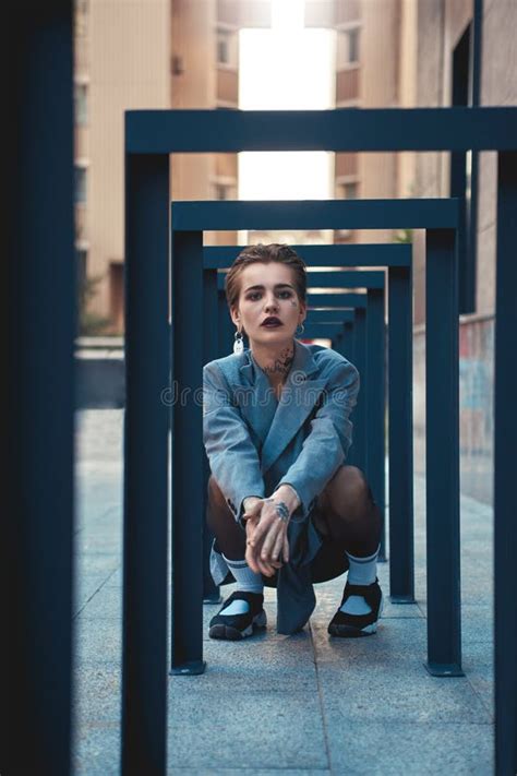 Urban Style Young Stylish Woman In Coat Sitting Outdoors Posing