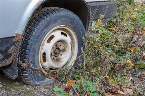 손상된 타이어 자동차 타이어 누출의 바퀴 수리를 기다리는 플랫 타이어 주차장에서 버려진 자동차 0명에 대한 스톡 사진 및 기타
