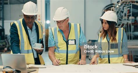 공장 또는 생산 창고에서 팀으로 노트북을 함께 작업하는 정비사 엔지니어 및 기술자 유지 보수 및 수리 작업 중에 랩톱에서 작업을 대화 계획 및 토론합니다 건설 현장에 대한