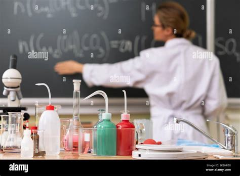 Teacher Explaining How To Read A Chemical Equation On A Chalkboard During A Chemistry Lesson