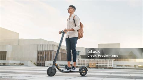 여행 친환경 교통 수단 및 출퇴근길에 환경과 지속 가능성을 갖춘 도시를 위해 스쿠터를 탄 남자 젊은 힙스터 전기 스쿠터 도시 풍경의 깨끗한 탄소 발자국 동기 이동식 스쿠터에