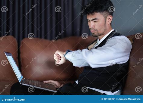 Portrait Of A Handsome Discreet Asian Man Sitting On The Sofa Using A Computer Stock Image
