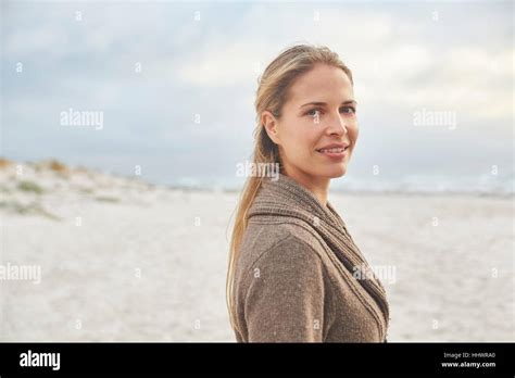 Portrait Smiling Blonde Woman On Winter Beach Stock Photo Alamy