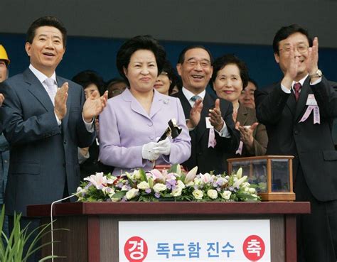 [노무현사료관] [해군대형수송함 독도함 진수식에서 진수도끼 타격을 마친 뒤 박수치는 노무현 대통령 내외]