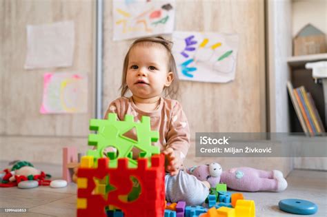 한 아기 작은 백인 유아 소녀가 낮 앞보기에서 플라스틱 장난감을 들고있는 집 복사 공간에서 바닥에서 놀고 있습니다 놀기에 대한 스톡 사진 및 기타 이미지 Istock