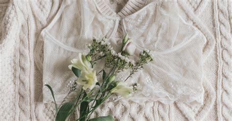 세련된 레이스 란제리와 봄 꽃이 아늑한 베이지 색 스웨터에 있습니다 부드러운 트렌디한 여성스러운 이미지 행복한 여성의 날 여성 필수품 향수 사진 Unsplash의