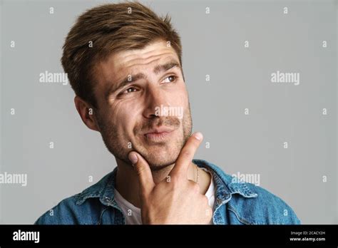Portrait Of Redhead Puzzled Man Posing And Thinking At Camera Isolated Over Grey Background