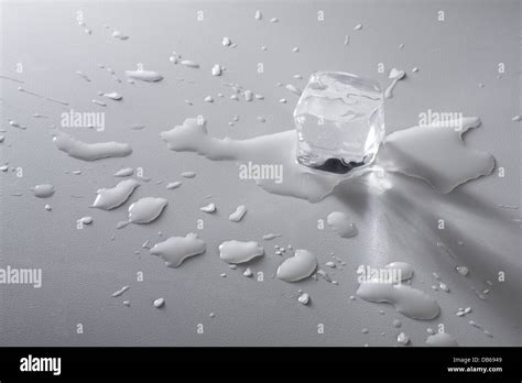 Ice Cube Melting With Puddles Of Water Stock Photo Alamy