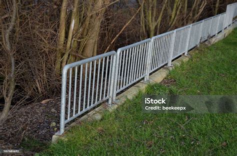 4 개의 콘크리트 나사로 땅에 고정 된 수직 울타리 막대가있는 다리의 난간 플라스틱 모자 잔디 공원 스트림 간단한 극 파이프 강철에 대한 스톡 사진 및 기타 이미지 Istock