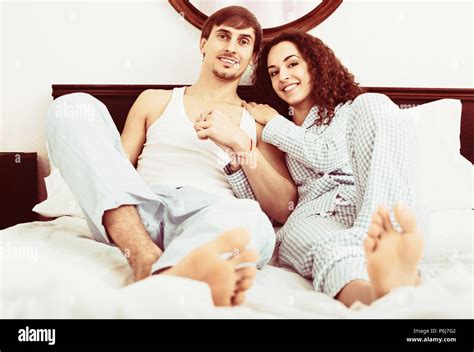 Handsome Young Husband And Smiling Brunette Wife Posing In Bed Stock