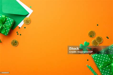 성 패트릭의 날 개념 빈 공간이 있는 격리된 주황색 배경에 편지 금화 클로버 빨대와 색종이가 있는 녹색 선물 상자 봉투의 상위 뷰 사진 3월에 대한 스톡 사진 및 기타