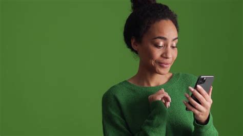 Positive African Woman In Green Shirt Flipping Tape By Phone Stock Footage