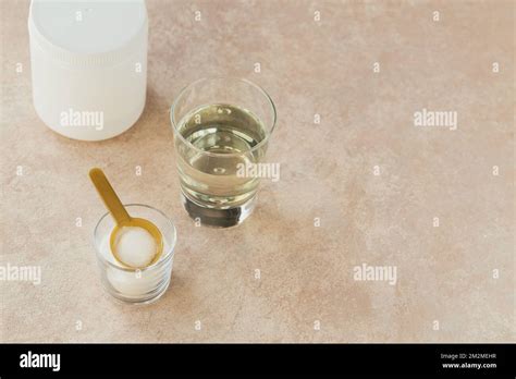 Glass With Collagen Dissolved In Water And Collagen Protein Powder On A
