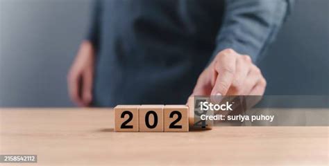 사업가는 2024년부터 2025년까지 새해에 나무 블록 큐브를 손으로 조립합니다 목표 동향 2025 분석 계획성장 전략 디지털 마케팅 이익 수입 및 기술 분석 2025년에