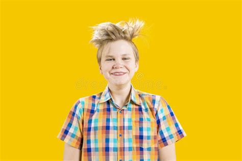 симпатичный мальчик с забавным лицом и неискушенной прической на жёлтом фоне непослушный