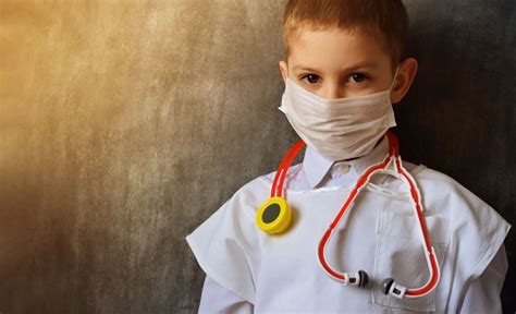 한 어린 소년이 보호용 얼굴 마스크를 쓰고 전화경을 들고 의사를 연기합니다 건강관리와 의술에 대한 스톡 사진 및 기타 이미지 건강관리와 의술 검사 보기 구급대원