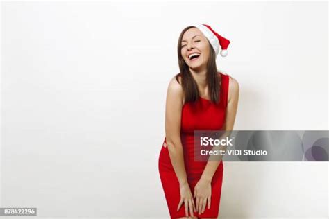 빨간 드레스와 그녀의 눈 웃음 크리스마스 모자를 입고 아름 다운 백인 젊은 행복 한 여자는 흰색 바탕에 기쁨과 함께 폐쇄 산타 여자 격리 된 초상화입니다 새 해 휴일