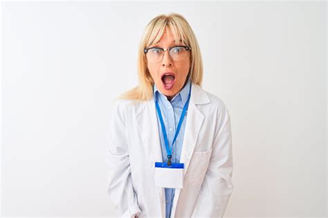 고립 된 흰색 배경 위에 안경과 신분증을 착용한 중년 과학자 여성은 놀라움의 표정 두려움 및 흥분된 얼굴로 충격을 받았습니다 감정에 대한 스톡 사진 및 기타 이미지 Istock