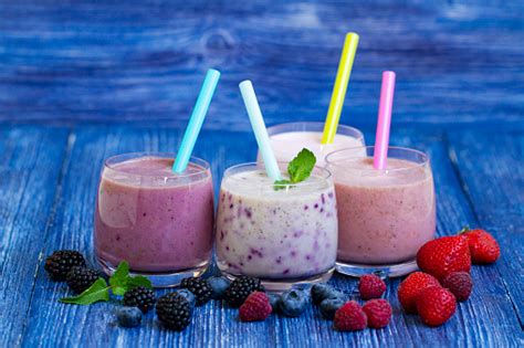 파란 나무 배경에 라스베리 딸기와 블루베리 스무디 신선한 딸기와 밀크 쉐이크입니다 블루베리와 라스베리 블랙베리의 베리 요구르트