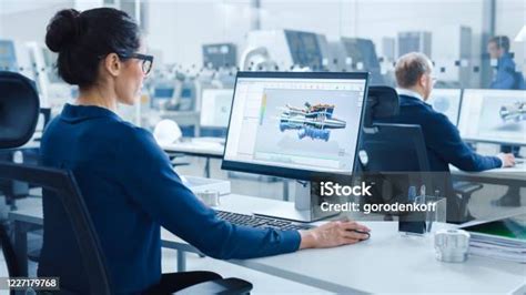 개인용 컴퓨터에서 작업하는 산업용 여성 엔지니어인 스크린은 엔진의 3d 프로토타입을 갖춘 Cad 소프트웨어를 보여줍니다 전문