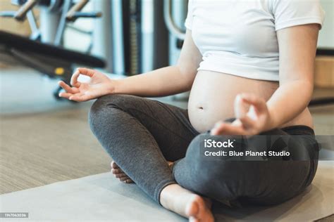 요가 룸의 피트 니스 센터에서 활동적인 임산부 운동 임신 뱃속에서 아기를 안고 있는 어머니를 기다리는 젊은 출산 태아 관리 및 여성 임신 개념 건강한 생활방식에 대한 스톡