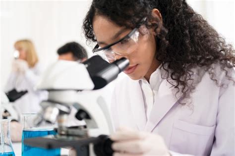 Premium Photo Lab Worker Using Magnifying Glass On Microscope
