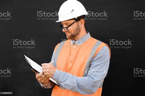 하얀 하드 모자와 오렌지 웨스트의 남성 엔지니어 잘 생긴 자신감있는 빌드 작업자는 빈 검은 색 배경에 고립되어 있습니다 복사