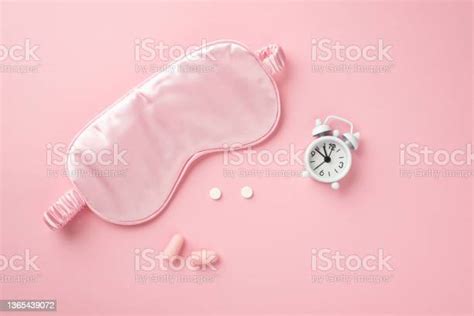 분홍색 실크 수면 마스크 작은 흰색 알람 시계 알약과 카피 스페이스와 고립 된 파스텔 핑크 배경에 귀마개의 상단 보기 사진 가리기에 대한 스톡 사진 및 기타 이미지 Istock