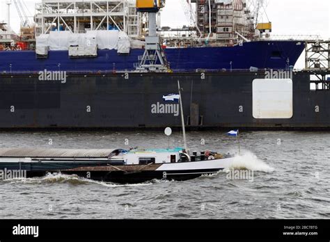 Photography Of A Small Freighter On A River Against Floating Dock Stock