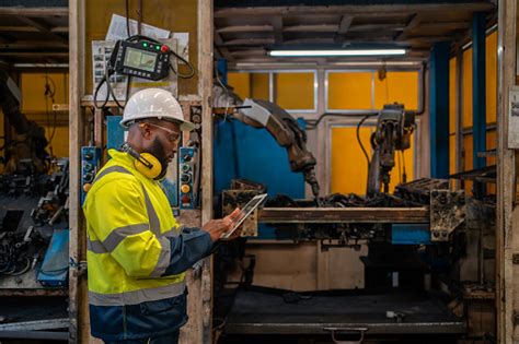 엔지니어 점검 및 제어 자동화 로봇 암 지능형 공장 산업용 로봇 암기계가 시스템 소프트웨어를 모니터링합니다 용접 로봇 및 디지털 제조 작업 30 34세에 대한 스톡 사진 및