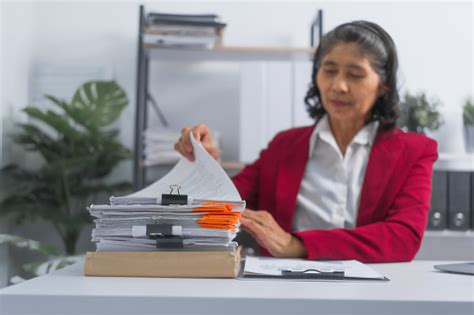 빨간 양복을 입은 자신감 넘치는 아시아인 노인 사업가가 책상 계획 부기 프로젝트에서 일하고 생각하고 읽고 직장에 앉아 있다 60 64세에 대한 스톡 사진 및 기타 이미지