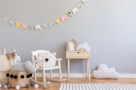 스칸디나비아 아이 룸 회색 벽 천연 바구니 어린이의 자에 테 디 베어와 디자인 장난감 다채로운 면 깃발 및 액세서리와 함께 나무 선반 귀여운 현대적인 인테리어 복사 공간