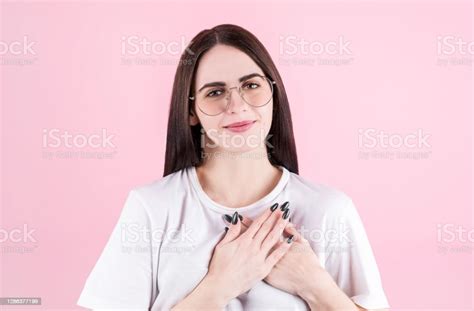 고립된 분홍색 배경 위에 흰색 티셔츠를 입은 젊은 아름다운 미국 여성은 눈을 감고 얼굴에 감사하는 제스처로 가슴에 손을 얹고 미소짓고 있습니다 암에 대한 스톡 사진 및 기타