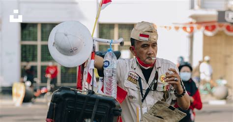 갈색 재킷과 갈색 바지를 입은 남자가 검은 배낭을 들고 있다 사진 Unsplash의 무료 거리 이미지