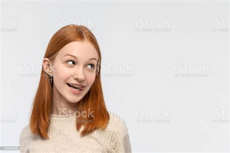 장난스럽게 혀를 보여주는 옆으로 찾고 빨간 머리 십대 소녀의 초상화를 닫습니다 귀여운 십대 소녀 여자는 흰색 배경에 고립 된 건강한 깨끗한 피부와 클로즈업 초상화에 직면