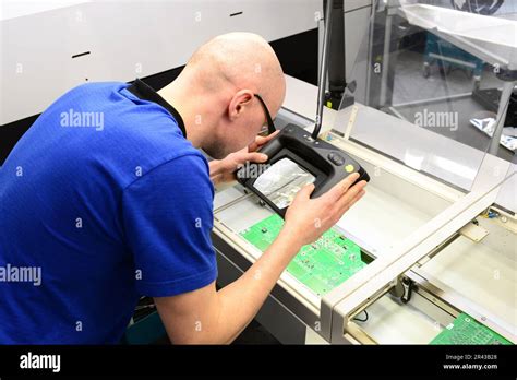 Quality Control In The Production Man Checks Board For Defects