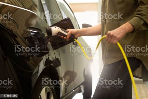 집에서 전기 자동차 소켓에 충전기를 연결하는 여성 손의 클로즈업 전기 자동차 대체 연료 자동차에 대한 스톡 사진 및 기타 이미지 전기 자동차 대체 연료 자동차 충전