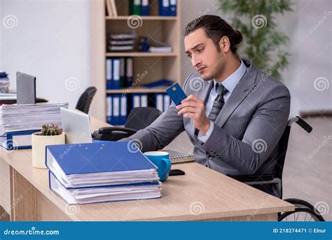 Jovem Trabalhador Do Sexo Masculino Em Cadeira De Rodas No Local De Trabalho Imagem De Stock