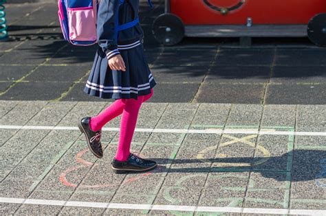 배낭을 멘 여학생은 학교 운동장에서 홉스카치를 하고 분필로 그린 사각형에서 쾌활하게 점프합니다 10 11세에 대한 스톡 사진 및 기타 이미지 Istock
