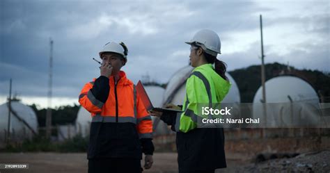 두 명의 프로젝트 산업 엔지니어가 정유 공장의 화학 저장 탱크 구역에서 안전에 대해 논의하고 있습니다 2명에 대한 스톡 사진 및 기타 이미지 Istock
