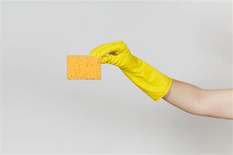 노란 장갑 가로 청소 및 설거지 흰색 배경에 고립 된 노란색오렌지 스폰지를 보유 하 고 있는 여성 손의 닫습니다 청소 공급 개념입니다 광고에 대 한 공간을 복사 가사