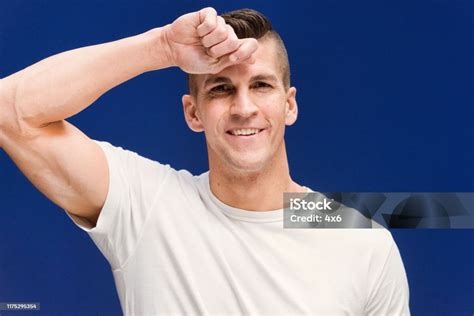 한 남자만 한 사람 허리 헤드샷 세로 정면 3039세 성인 잘생긴 사람 갈색 머리 짧은 머리 백인 남성 젊은 남자의 카메라를 보고 머리 뒤에 손으로 파란색 배경 앞에 서