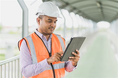 아시아 토목 엔지니어는 태블릿으로 운영하여 건설 작업을 제어합니다 고속도로 콘크리트 도로 현장에서 단단한 모자를 쓰고 있는 작업자 건설 현장에 대한 스톡 사진 및 기타