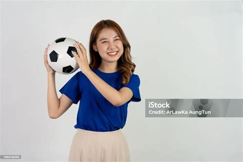 예쁜 아시아 여자 축구 팬들이 고립된 흰색 배경에 축하를 하고 있다 파란색 티셔츠를 입은 아시아 소녀가 흰색 배경에 축구공을