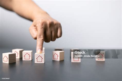 주택 및 부동산 투자 및 자산 관리 개념입니다 이자율 대출 모기지 주택세 퍼센트 아이콘이 있는 스택에서 나무 블록에 집 아이콘을 들고 있는 손 텍스트를 위한 공간을